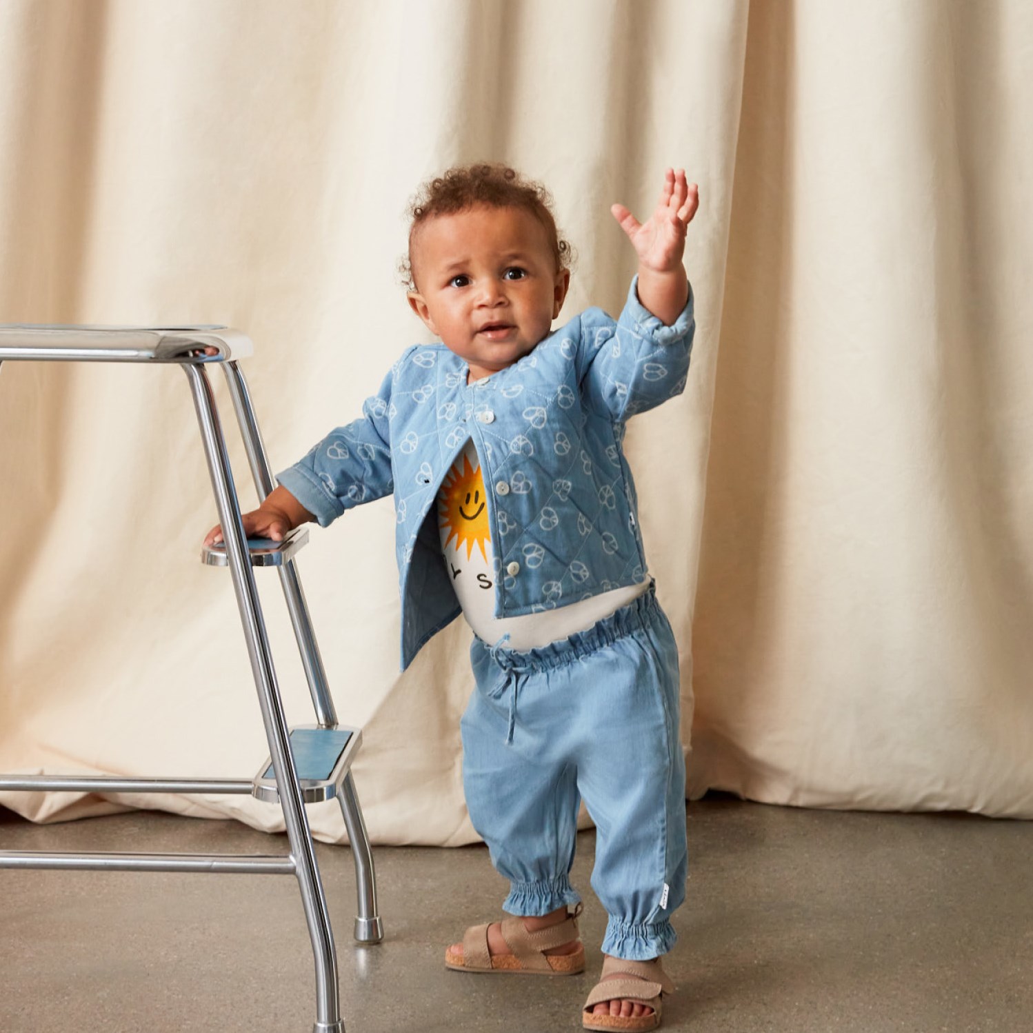 Fossie - Pearled Ivory - Light coloured baby bodysuit with happy sun - Molo